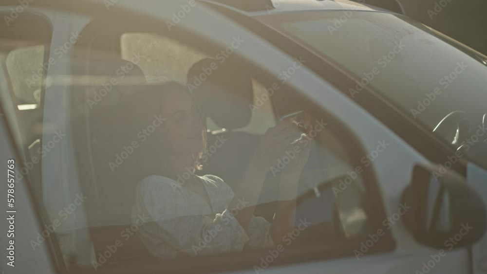 mid shot attractive woman in light white dress sitting in car cabin ...