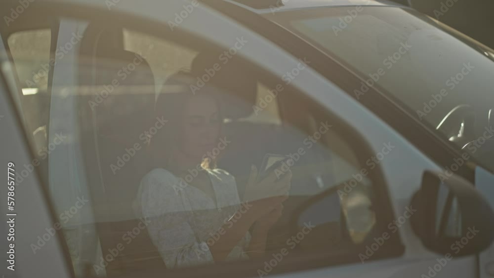mid shot attractive woman in light white dress sitting in car cabin ...