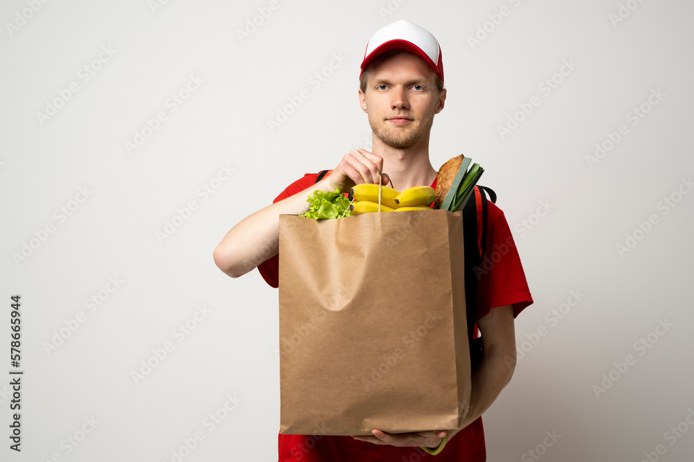Happy delivery man in red uniform with cap and thermal bag backpack ...