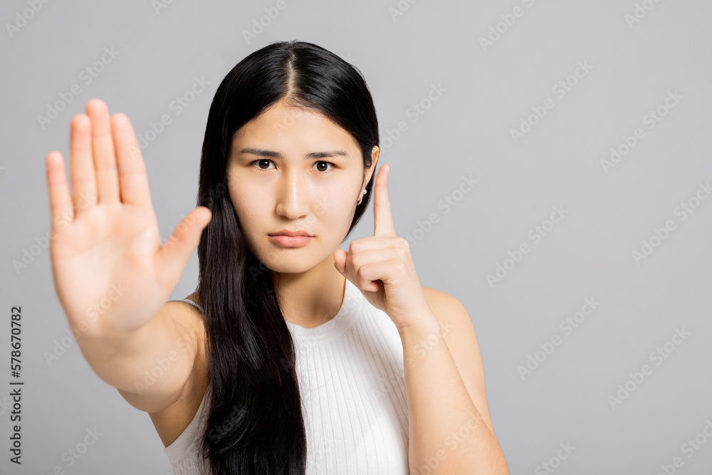 Young adorable asian woman wearing casual white t-shirt doing stop sing ...