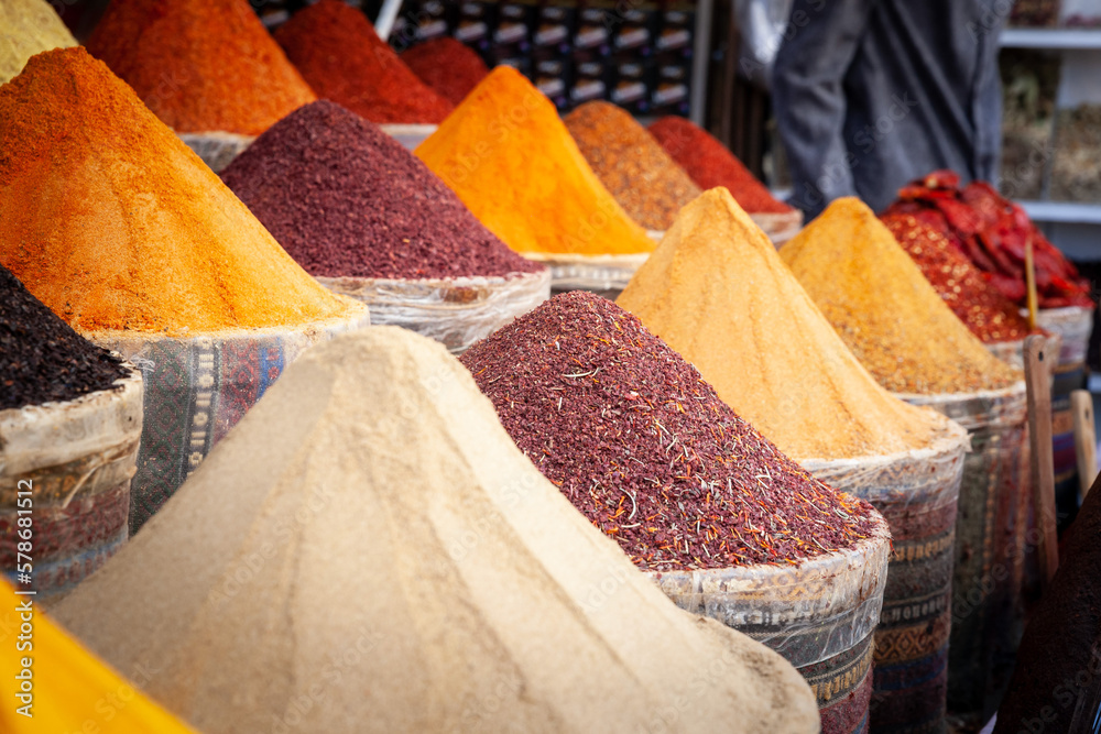Selective blur on piles of spices of various colors and tastes, used in ...