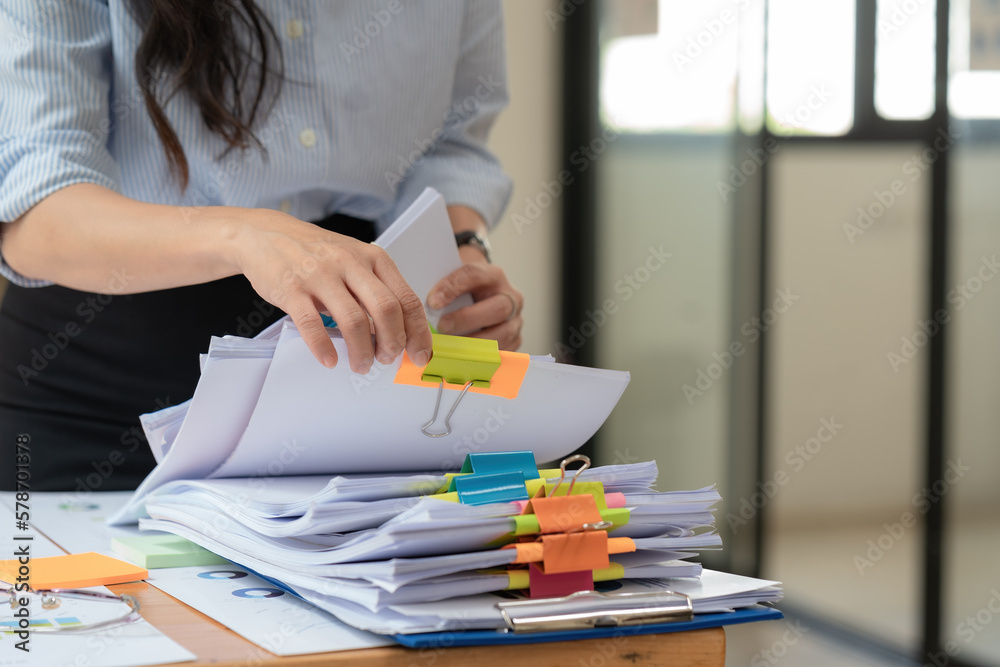 Businesswoman hands working in Stacks of paper files for searching and ...
