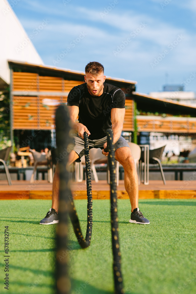 Handsome young man using the ropes in the outdoor gym Stock Photo ...