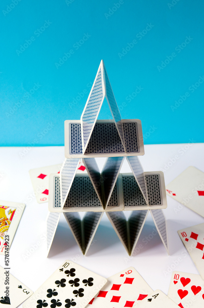 Playing card pyramid made with poker cards on a blue background and ...