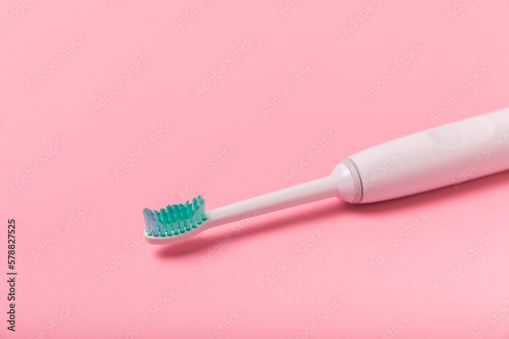 Electronic ultrasonic toothbrush on a pink background.Smart electric ...