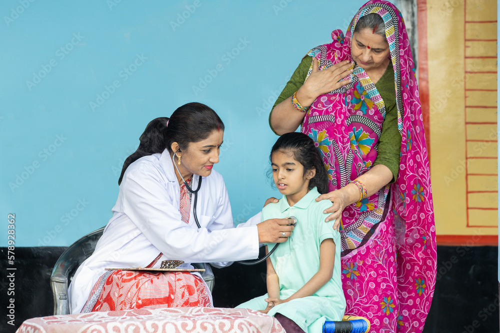 Foto de Indian female doctor examine little kid girl patient with ...