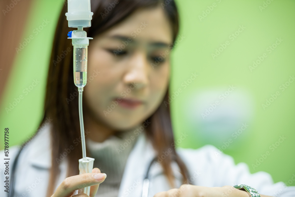 Woman doctor monitor Adjust the drip rate feed of saline dripping ...