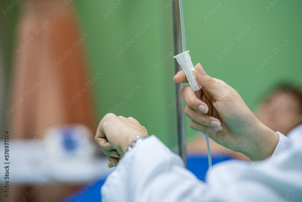 Woman doctor monitor Adjust the drip rate feed of saline dripping ...