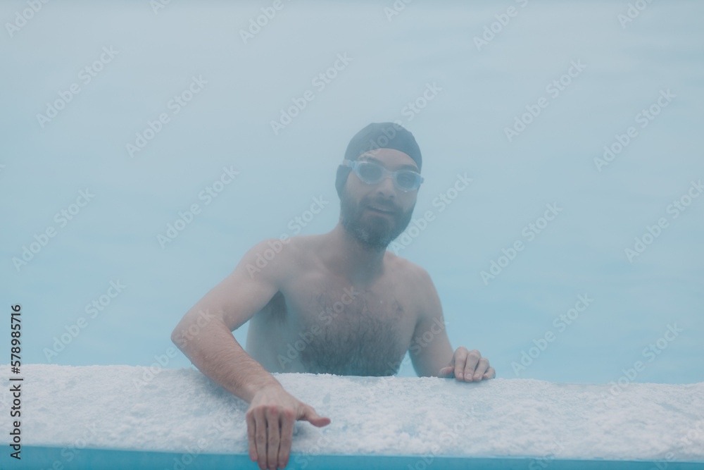 Fit swimmer male training swim in open winter swimming pool with fog ...