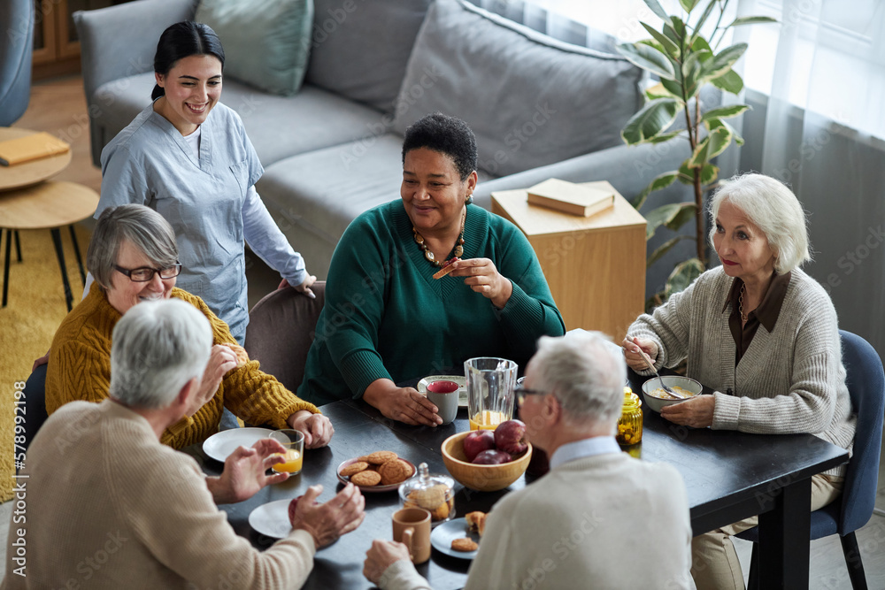 High angle view at group of senior people sitting at table together and ...