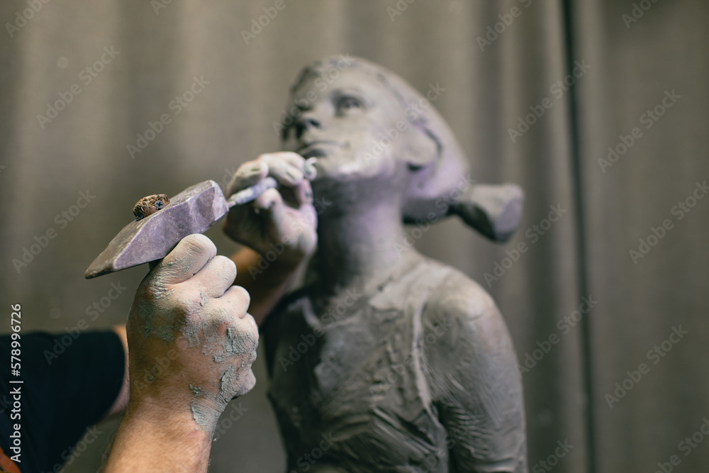 Man sculptor creates sculpt bust human woman sculpture with hammer ...