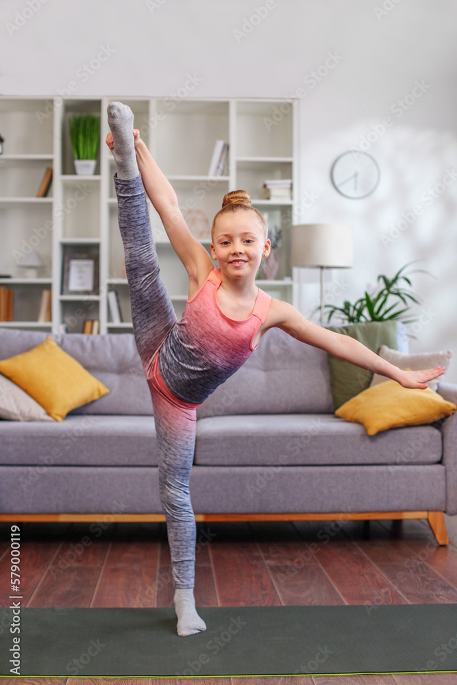 Little girl practicing stretching in room. Physical exercises for ...