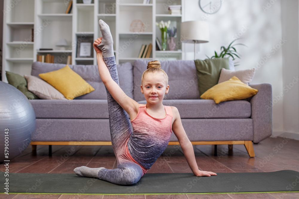 Little girl practicing stretching in room. Physical exercises for ...