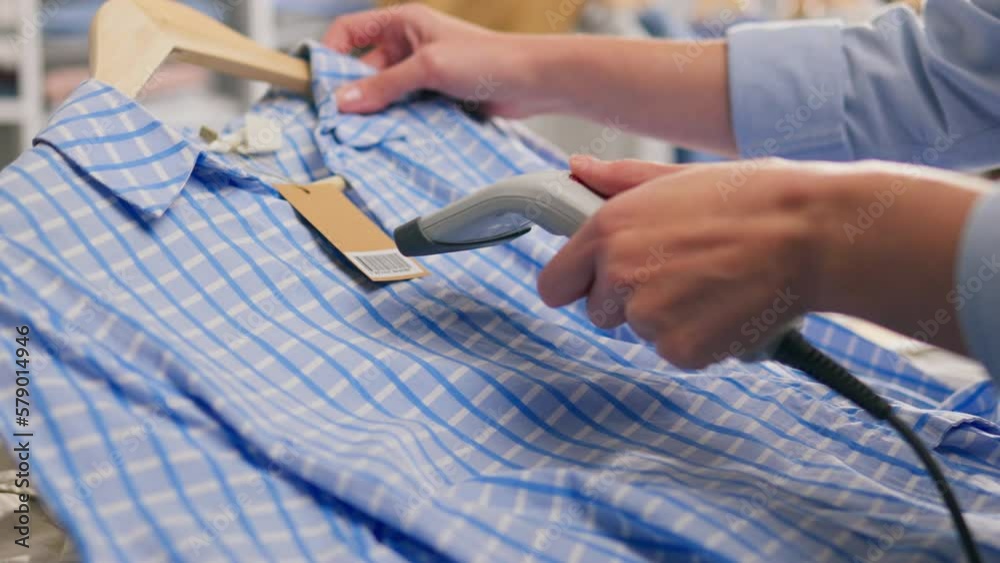 A shopper uses an RFID reader to scan a tag on a new piece of clothing ...