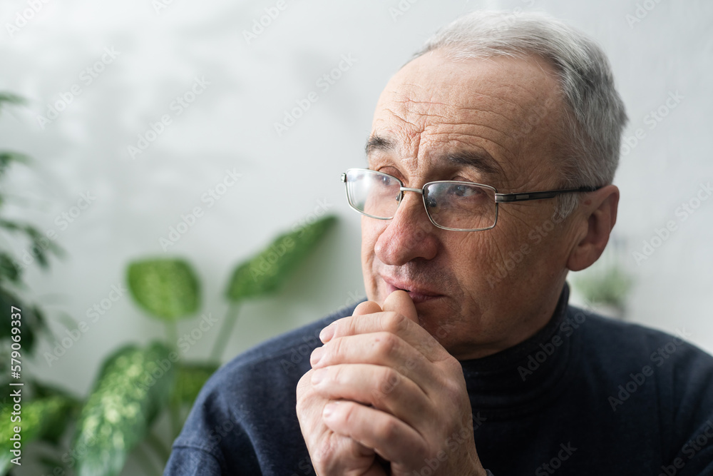 Worried religious senior man praying to god with his hands raised and ...