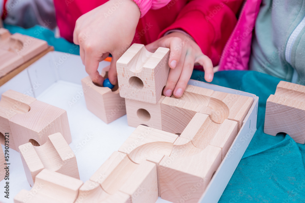Little toddler plays with a wooden constructor, preschool child ...