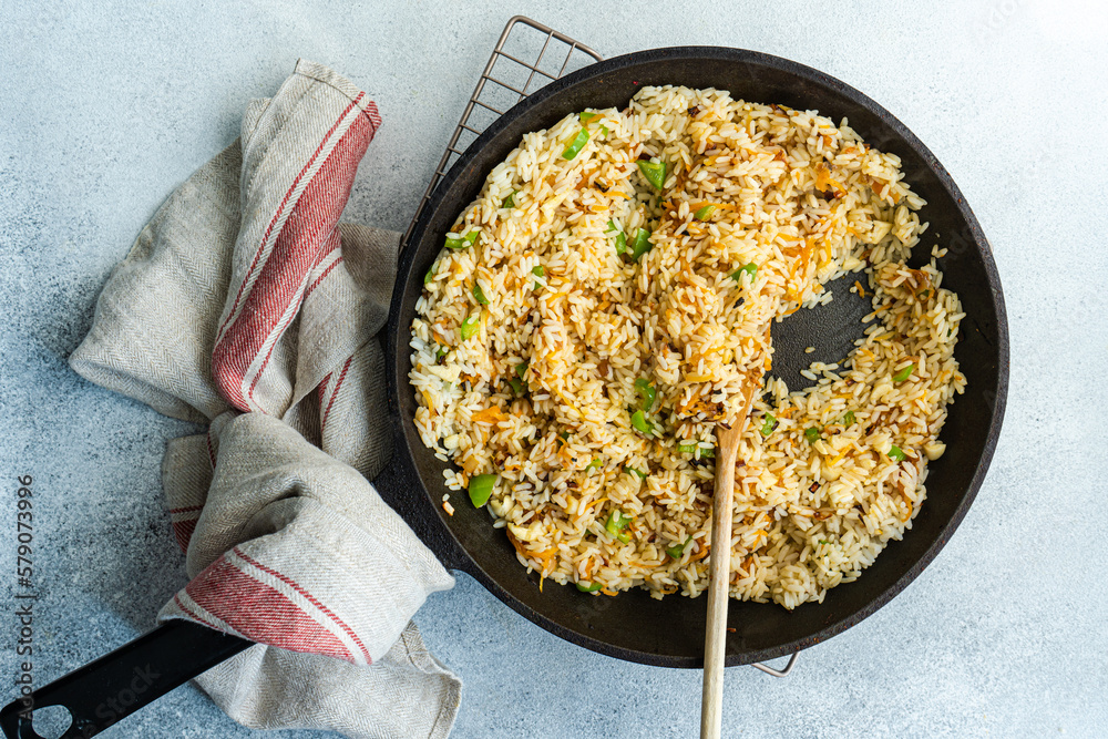Overhead view of fried rice with onions, carrots and green bell peppers ...