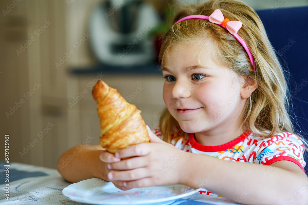 Smiling child at breakfast. Food and happy kids. The girl is eating a ...