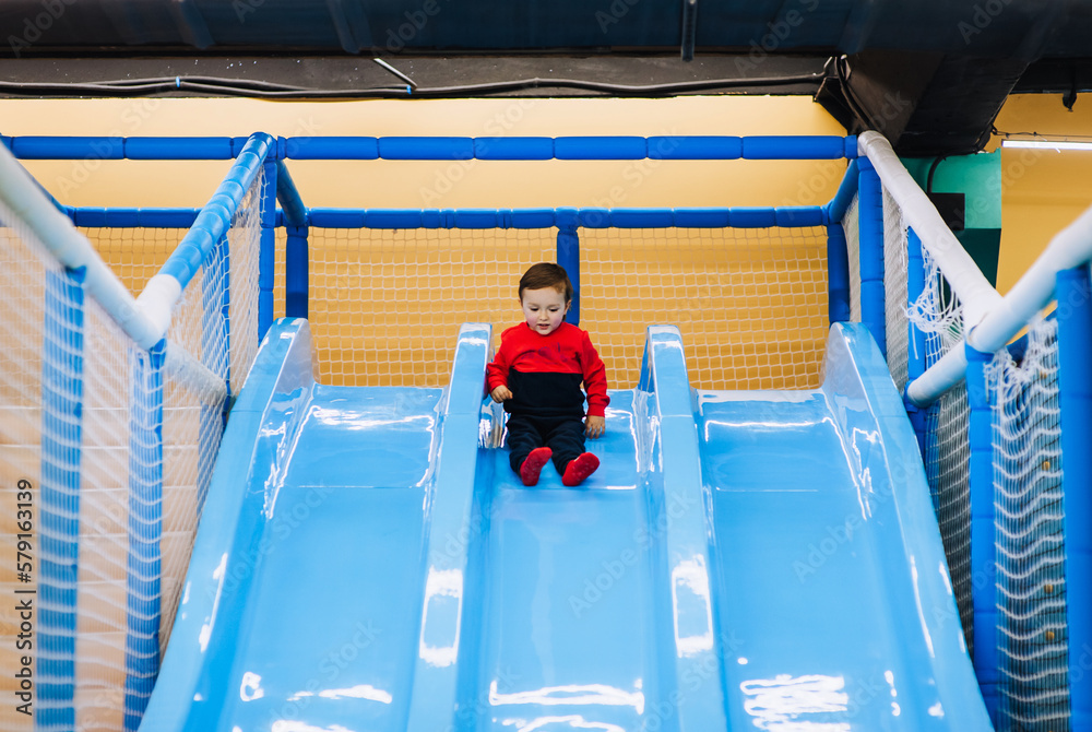 Happy, smiling handsome little boy, preschool child descends, slides ...