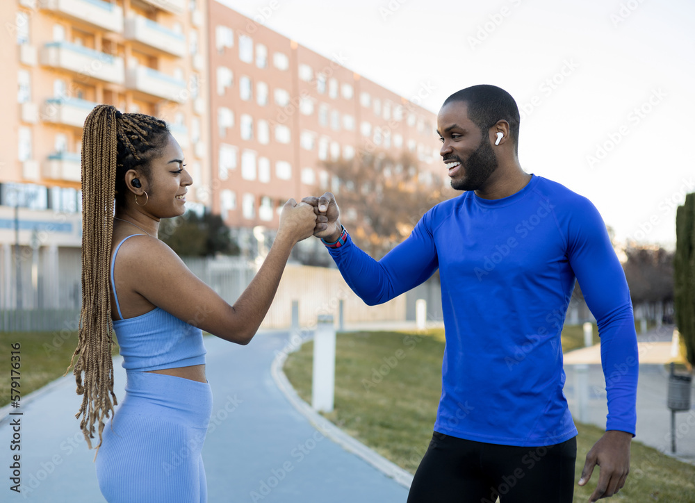 A dark-skinned couple spends an afternoon happily doing sports outdoors ...