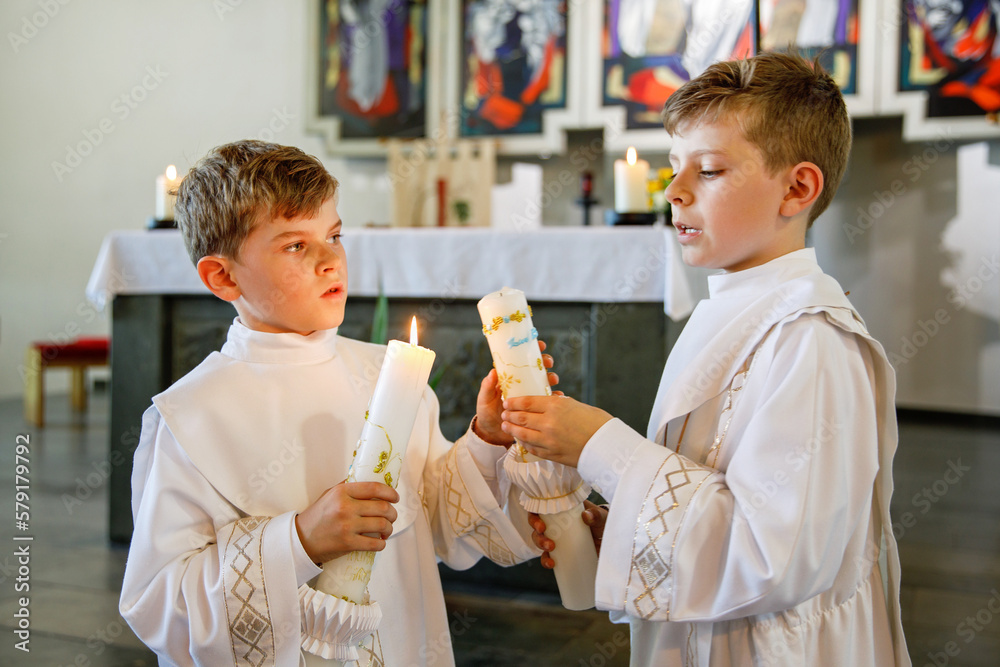 Two little kids boys receiving his first holy communion. Happy children ...