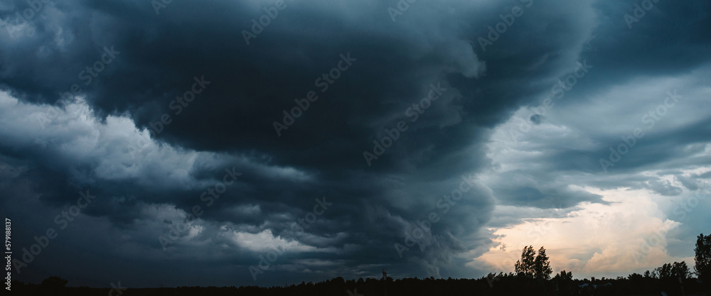Dramatic cloudscape. Sunny light through dark heavy thunderstorm clouds ...