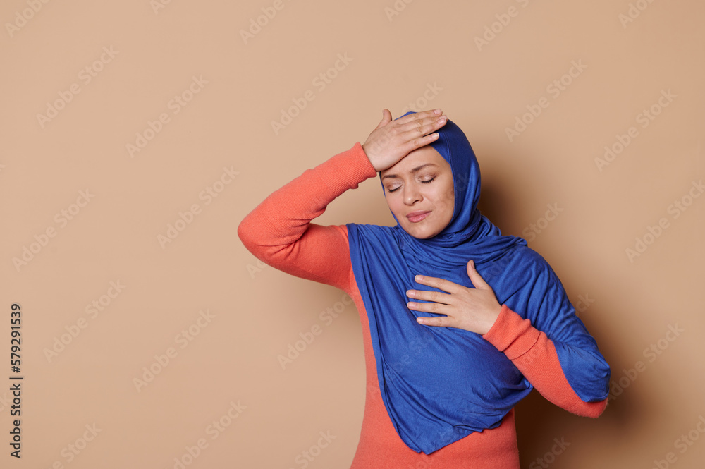 Muslim Arabic pretty woman dressed in blue hijab, holding her hand on ...