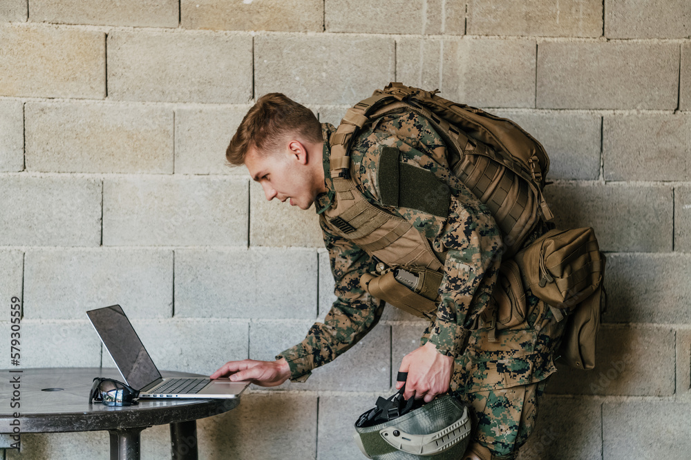 American soldier in military uniform using laptop computer for drone ...
