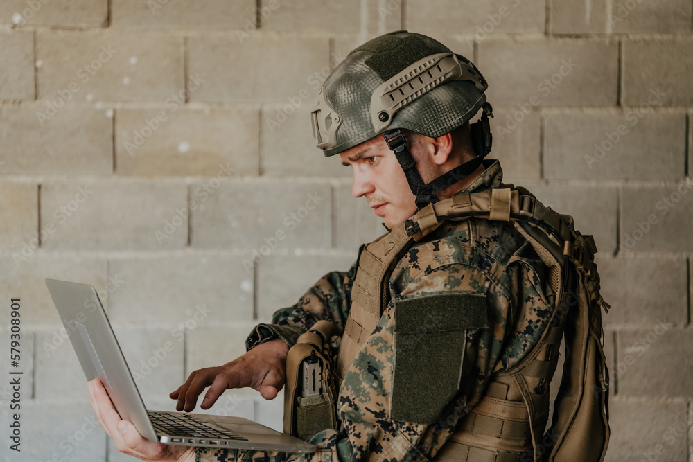 American soldier in military uniform using laptop computer for drone ...