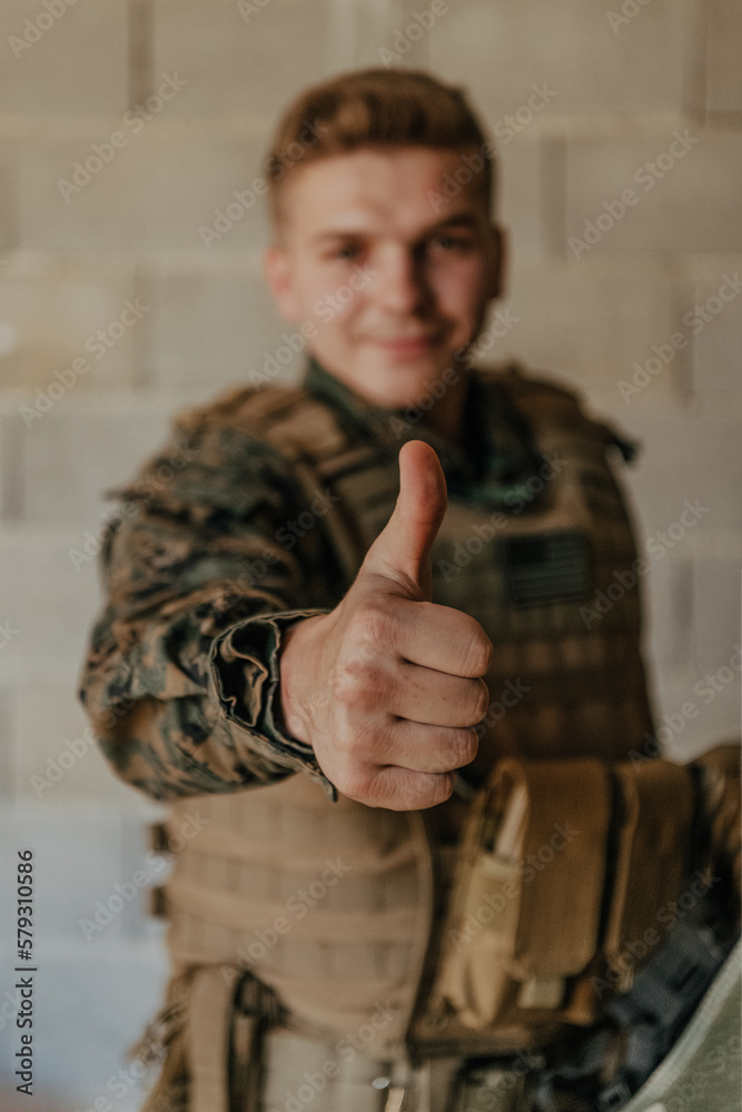 The soldier makes a gesture of success with his hand. A soldier in full ...