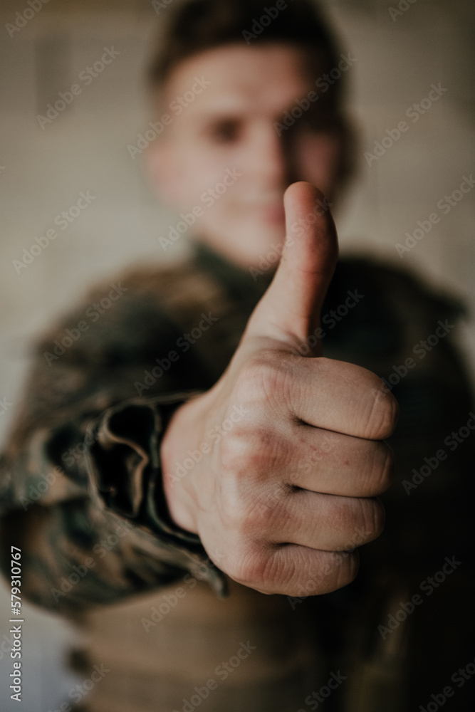 The soldier makes a gesture of success with his hand. A soldier in full ...