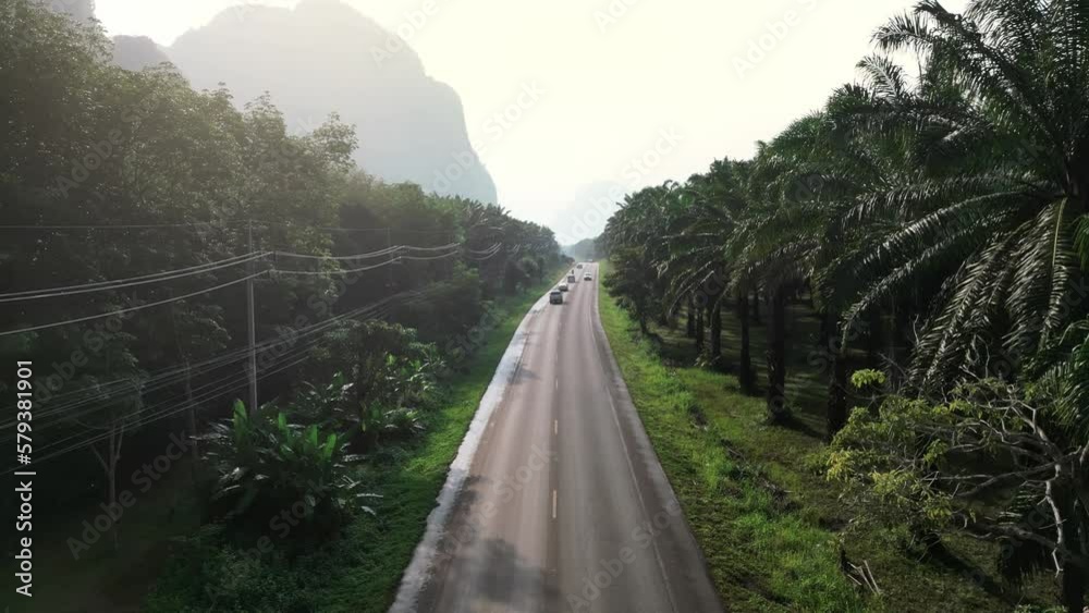 Wideo Stock: Drone shot flying over the roadway with passing cars in ...