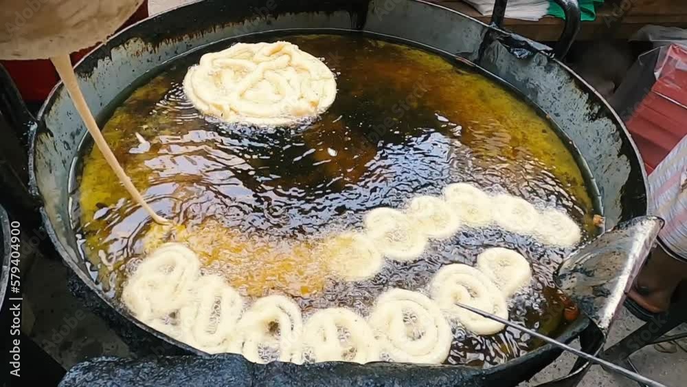 Frying deep of maida or plain flour batter before soaking in sugary ...