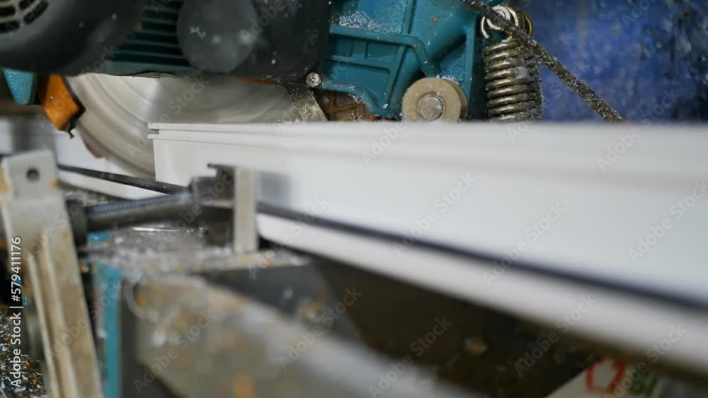 Video Stock Close-up cutting a white PVC profile with a miter circular ...