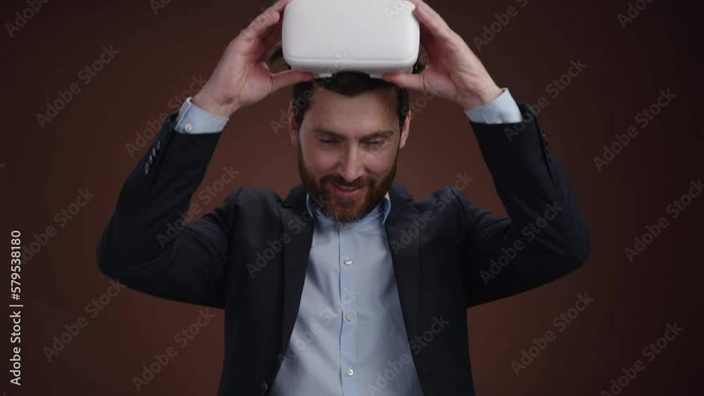 A man in a suit d taking off his vr headset with a happiness on his ...