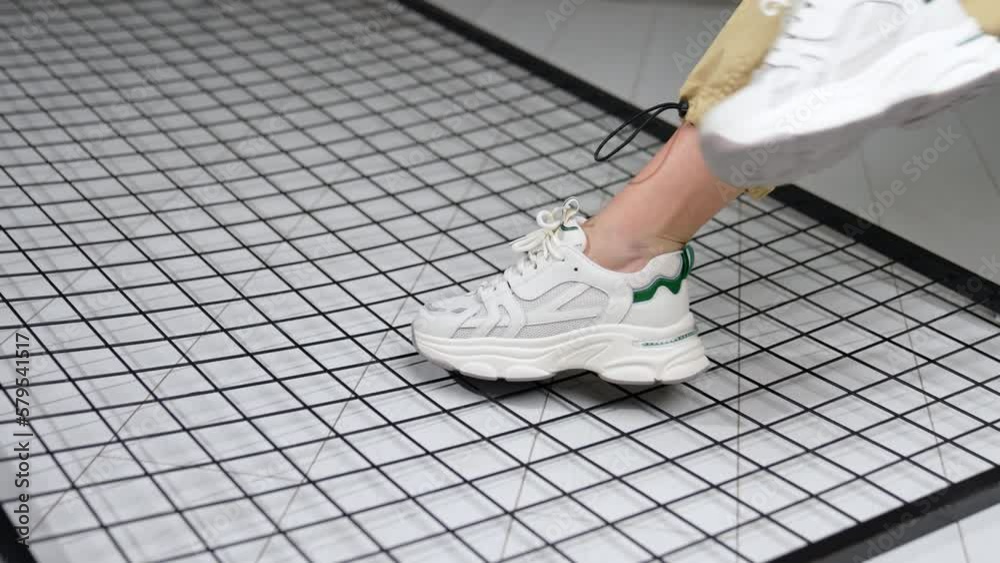 White stylish sports footwear on a model’s feet. Woman changing ...