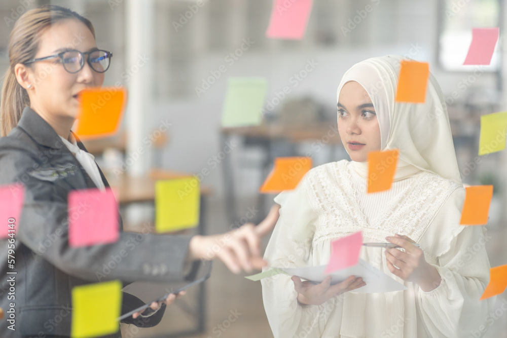 Young Asian woman Creative team use post it notes to share idea sticky ...
