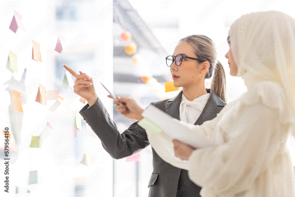 Young Asian woman Creative team use post it notes to share idea sticky ...