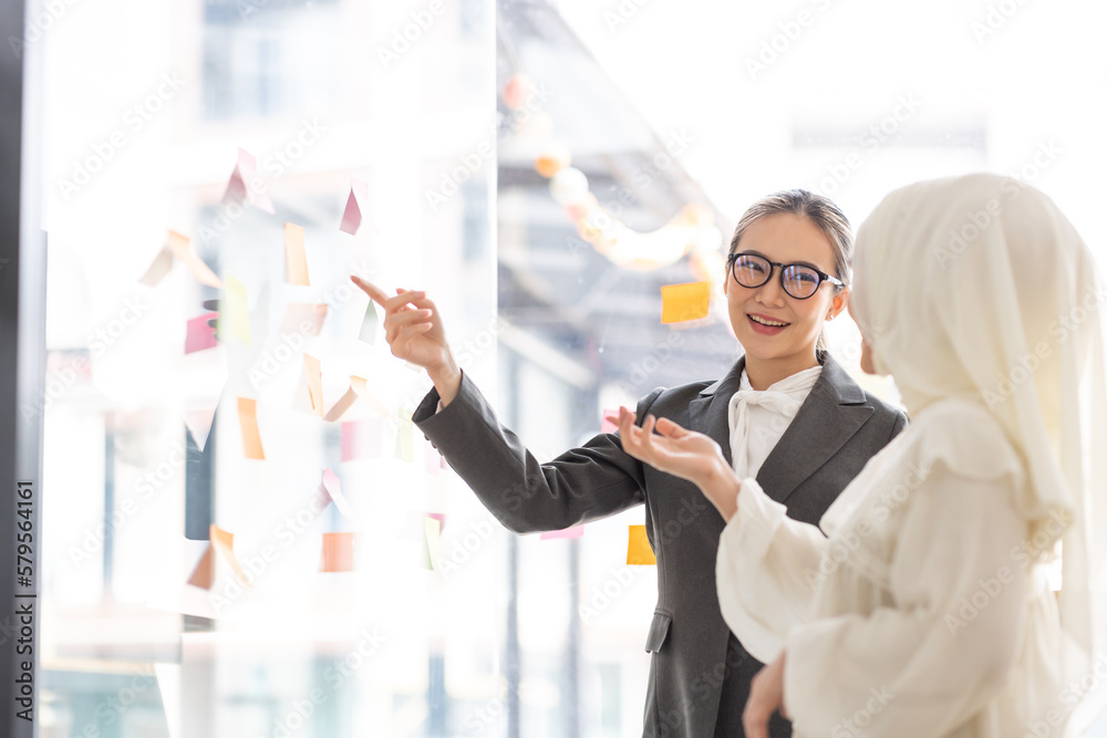 Young Asian woman Creative team use post it notes to share idea sticky ...