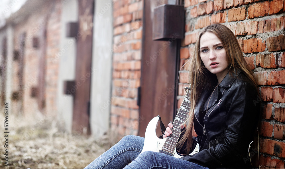 Beautiful young girl rocker with electric guitar. A rock musician girl ...