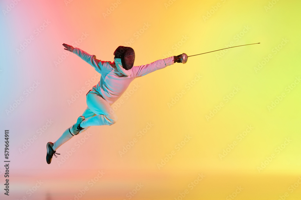 Long attack. Young man, male fencer with sword practicing in fencing ...