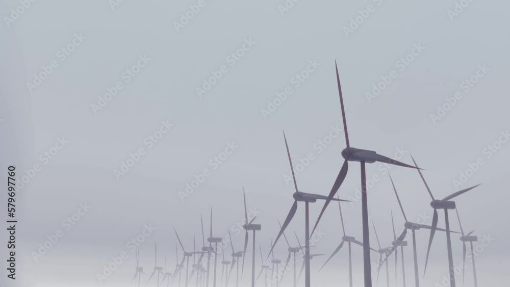 Wind farm with many rotating wind turbines on a cloudy day. Group of ...