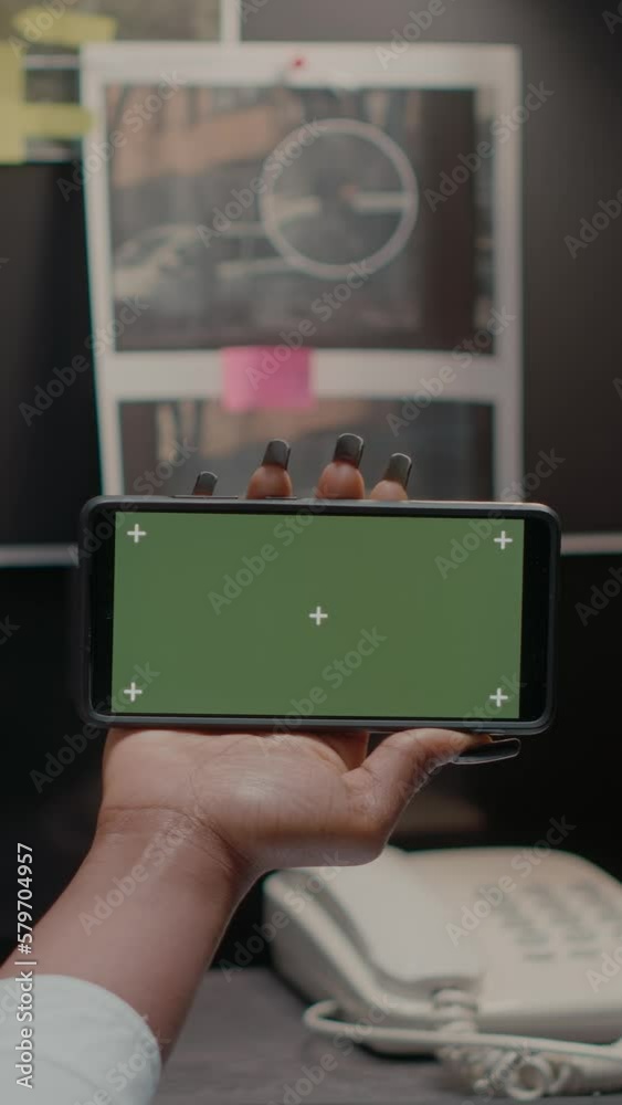 Vertical video: Police officer using greenscreen in evidence room ...
