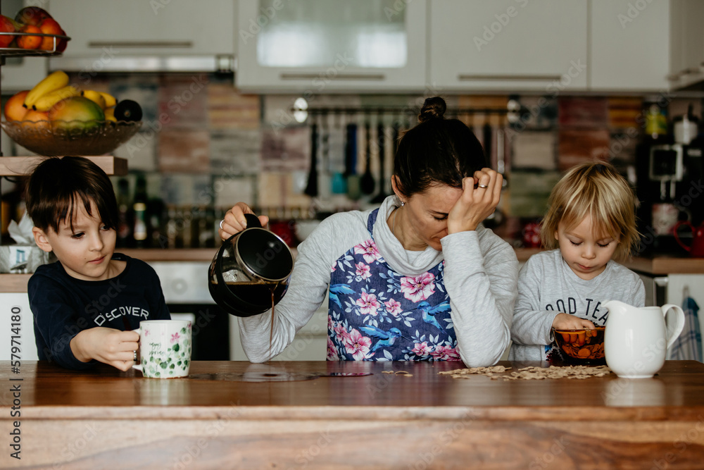 Foto de Tired mother, trying to pour coffee in the morning. Woman lying ...