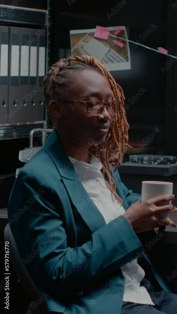 Vertical video: African american woman working in police archive space ...