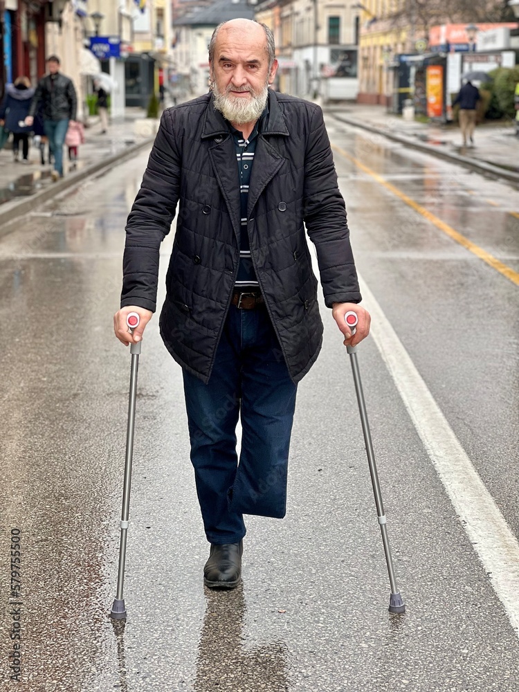 Disabled man without one leg walks in city park alone. Man with ...