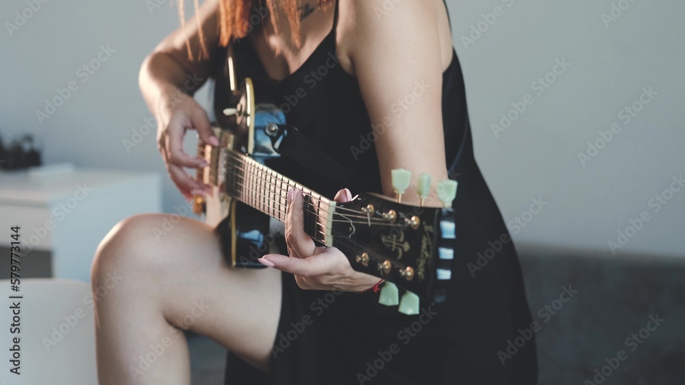 The close -up of the woman s hands is a musician in a black dress that ...