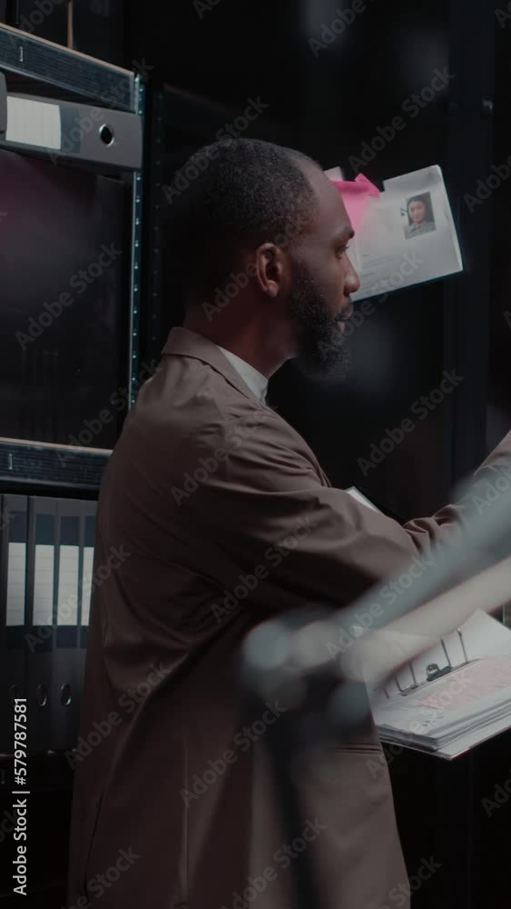 Vertical video: Private detective looking at evidence on board and ...