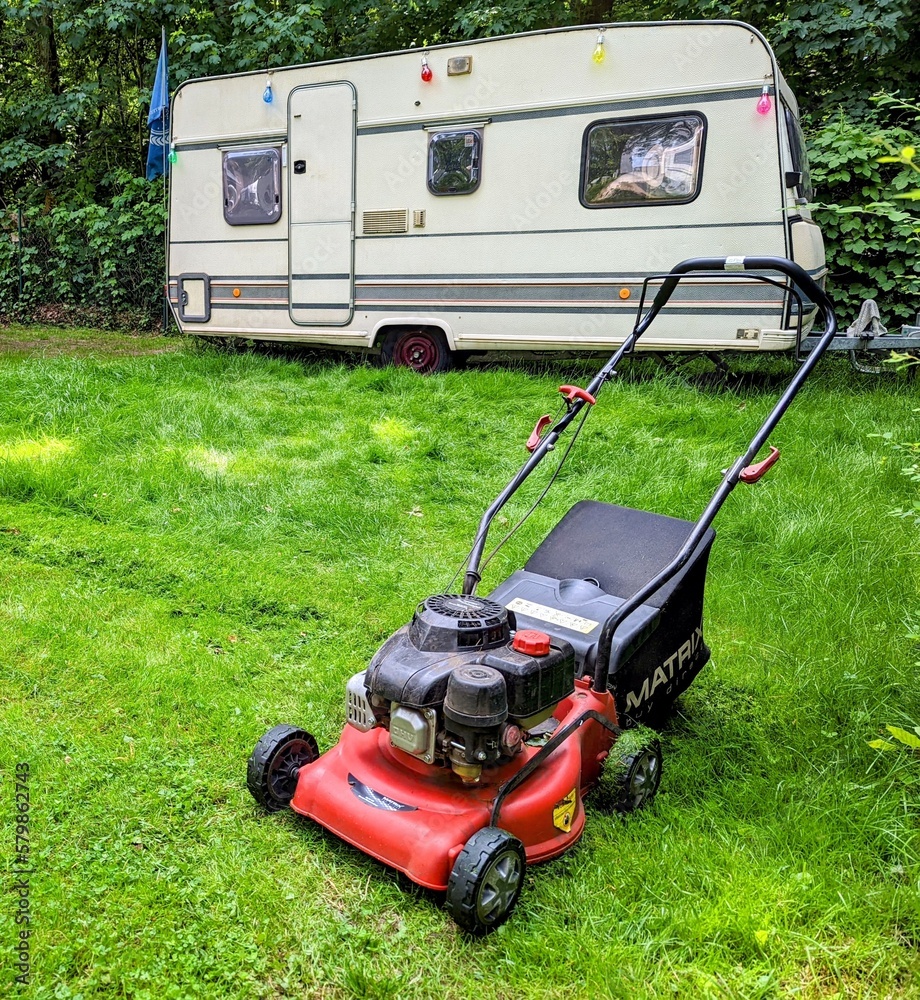 Berlin, 2022: Caravan on a campsite in the forest with a green meadow ...