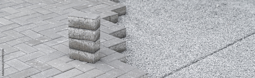 building a sidewalk, laying interlocking pavers, banner with copy space ...